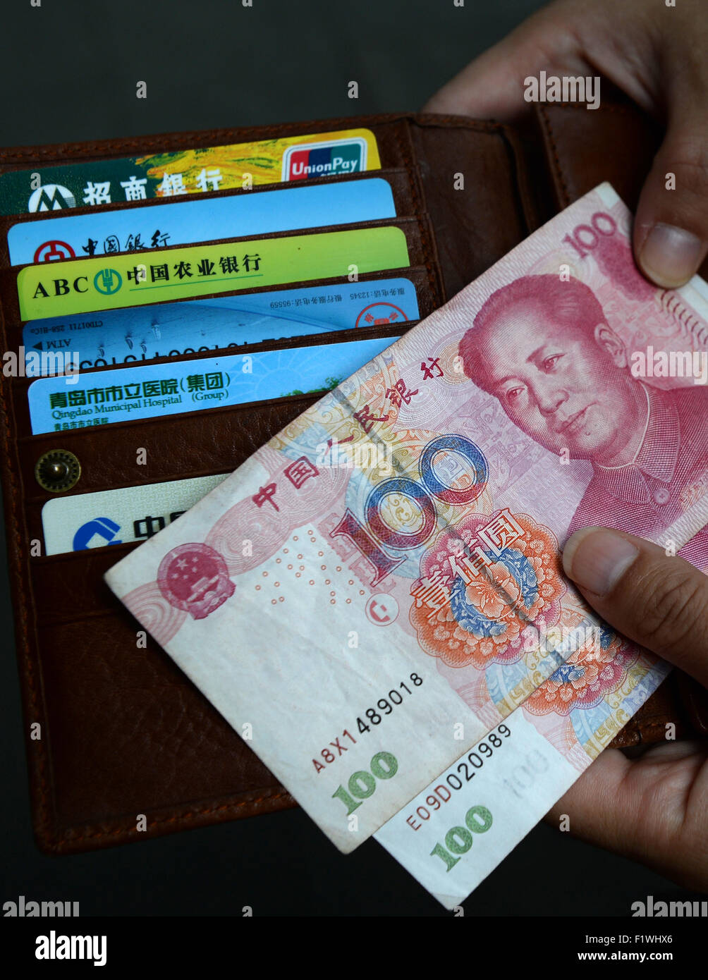 Shanghai, China. 30th Aug, 2015. A woman holds Chinese yuan banknotes ...