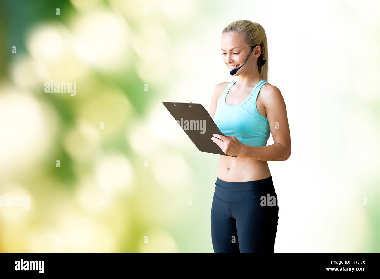 happy woman trainer with microphone and clipboard Stock Photo - Alamy