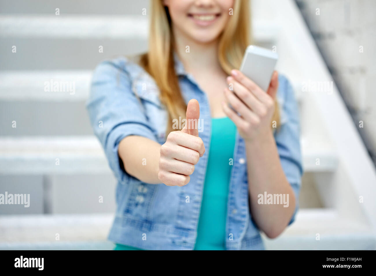female with smartphone showing thumbs up Stock Photo - Alamy