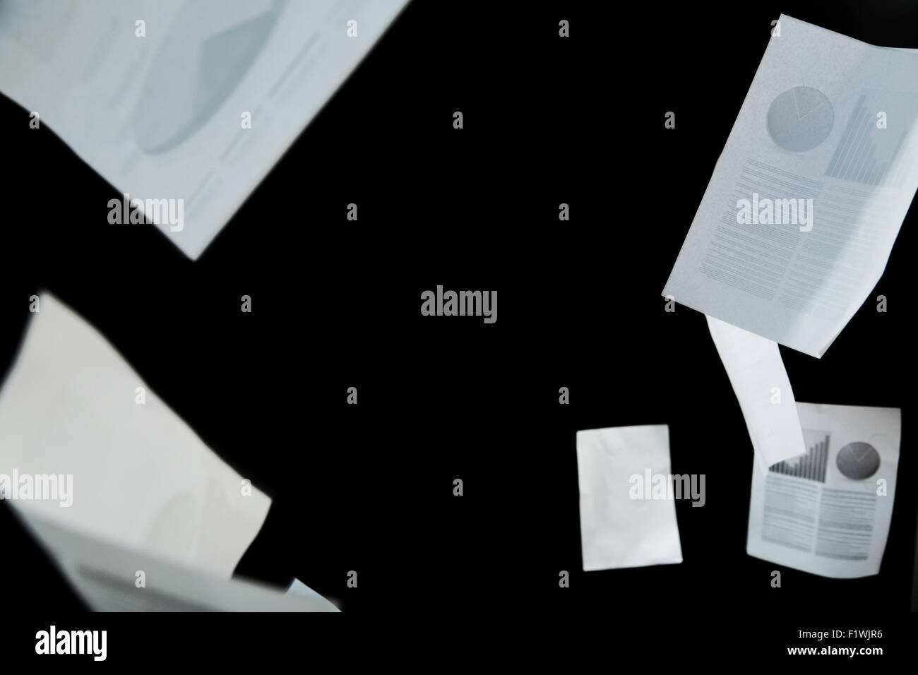 business papers falling down over black background Stock Photo - Alamy