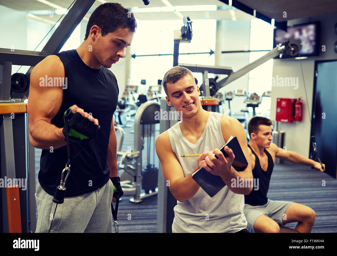 men exercising on gym machine Stock Photo - Alamy