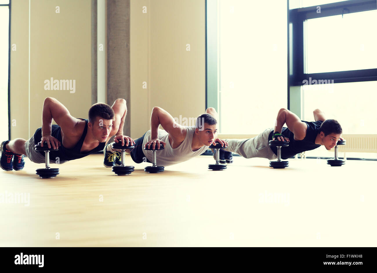 group of men with dumbbells in gym Stock Photo - Alamy