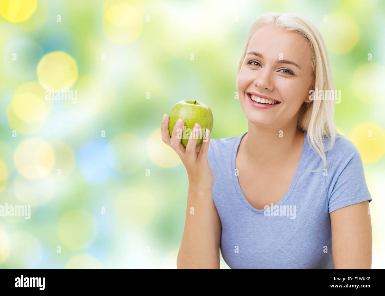 happy woman eating green apple Stock Photo - Alamy