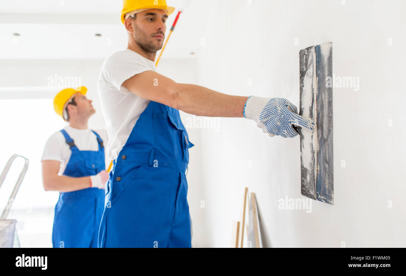 two builders with painting tools repairing room Stock Photo - Alamy
