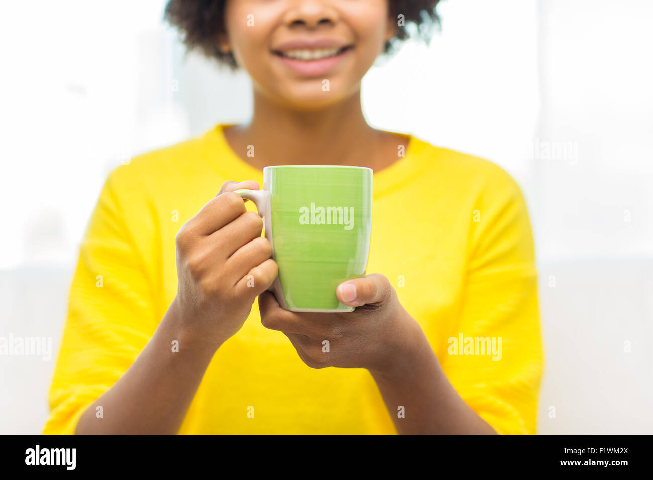 happy african american woman drinking from tea cup Stock Photo - Alamy