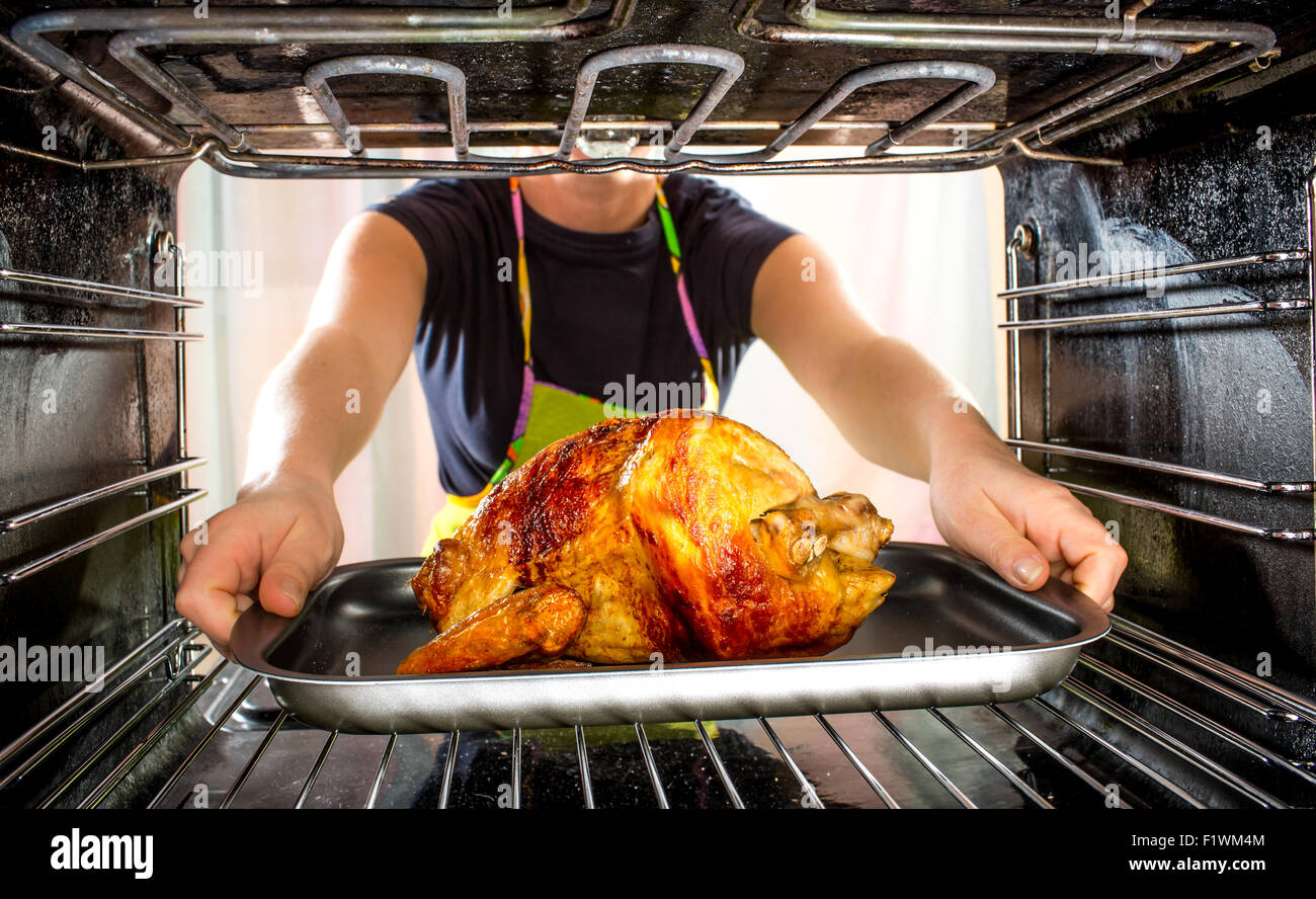 Housewife prepares roast chicken in the oven, view from the inside of ...