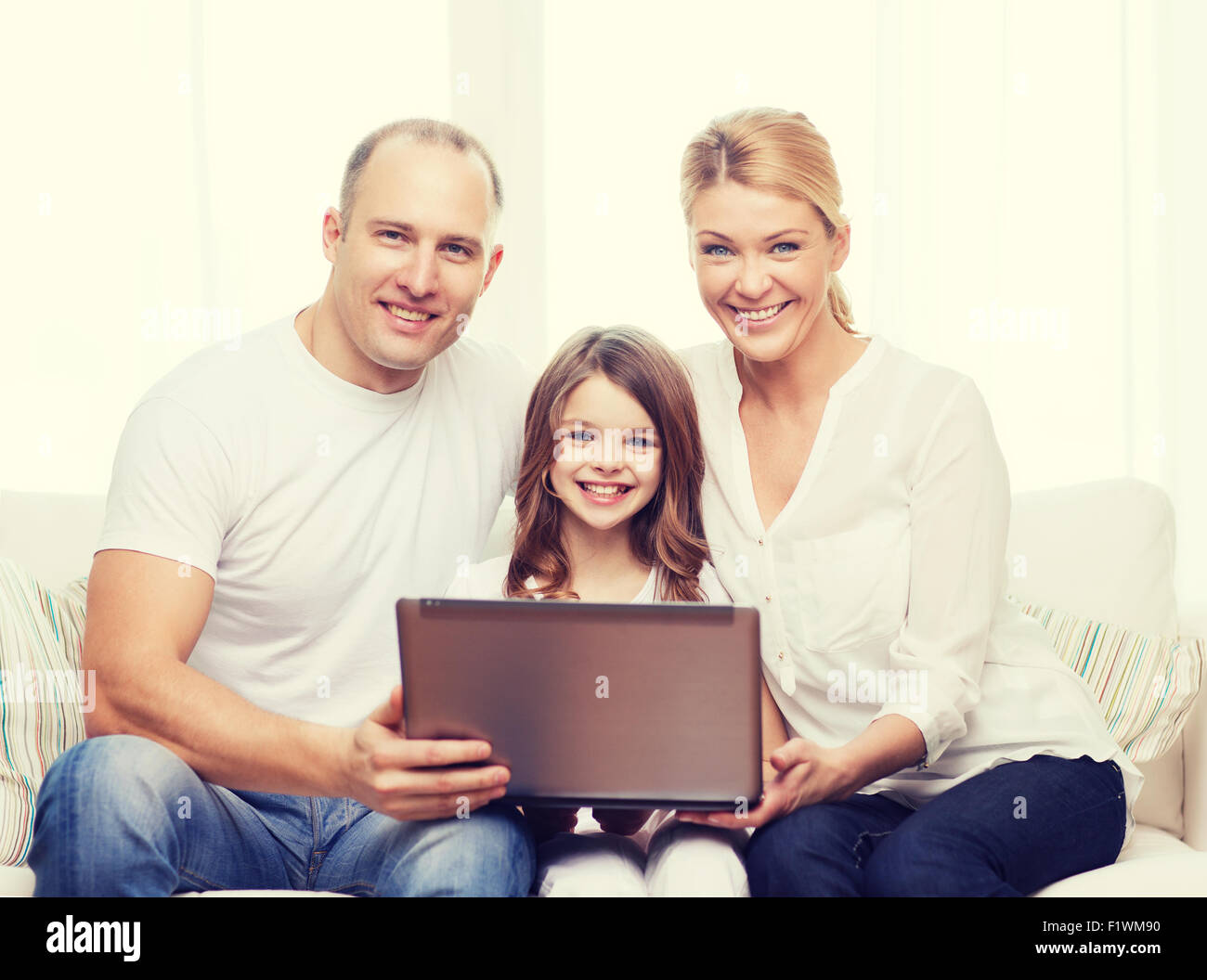parents and little girl with laptop at home Stock Photo - Alamy