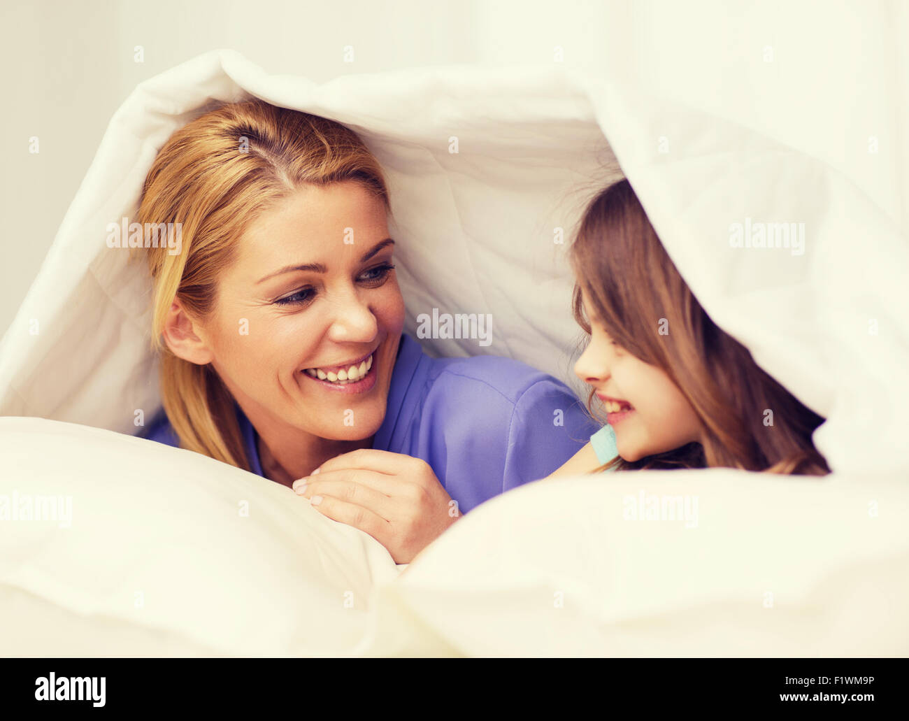 mother and little girl under blanket at home Stock Photo - Alamy