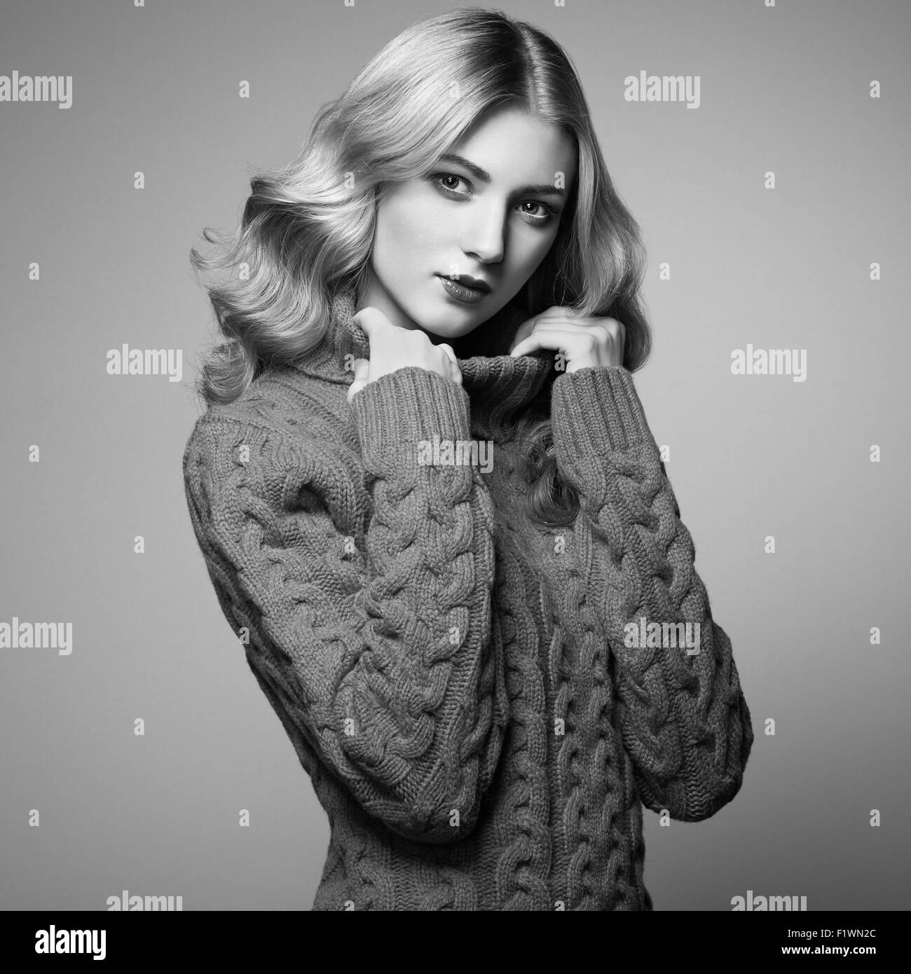 Fashion photo of beautiful woman in sweater. Curly hairstyle. Make-up ...