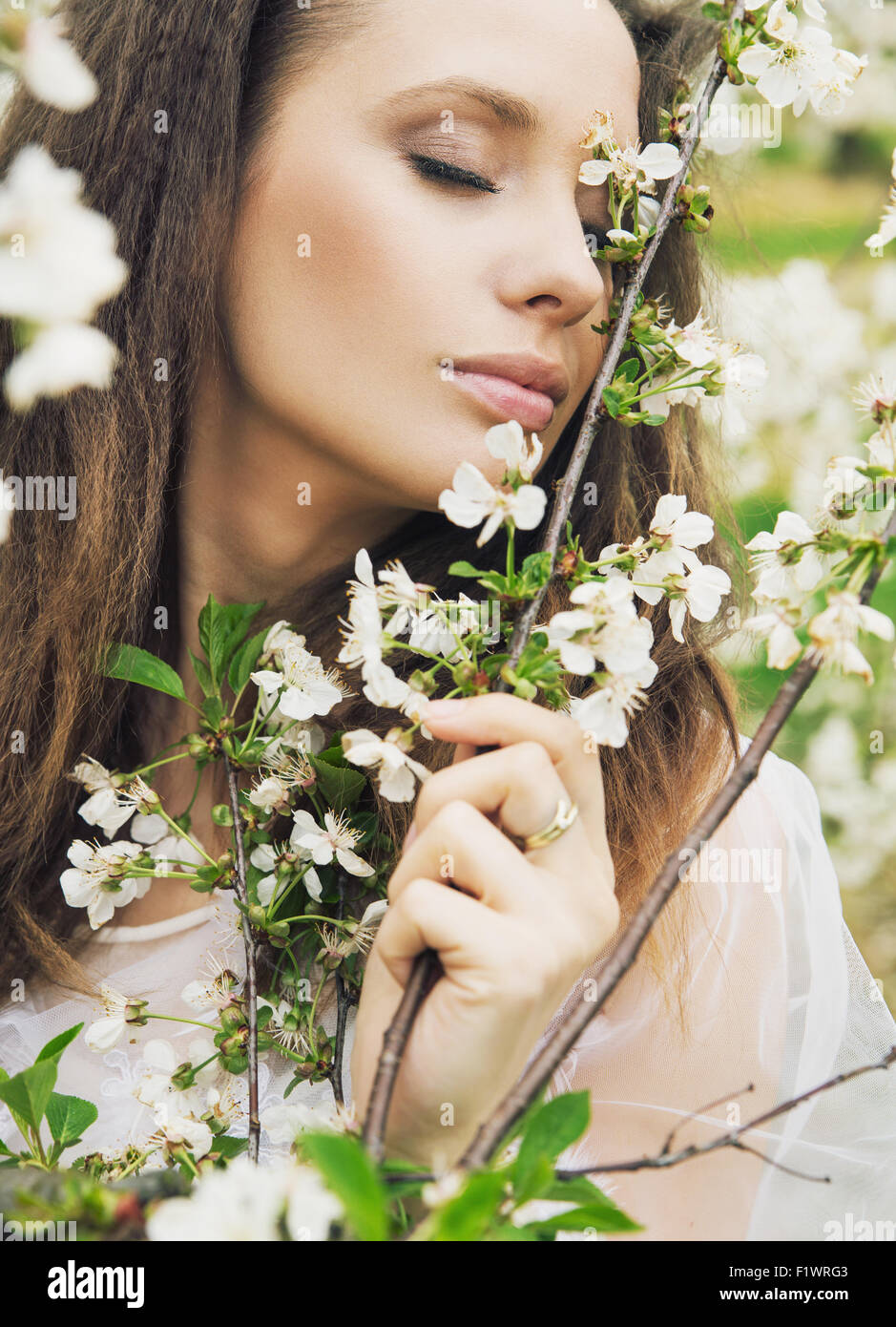 Attractive lady smelling wild flowers Stock Photo - Alamy