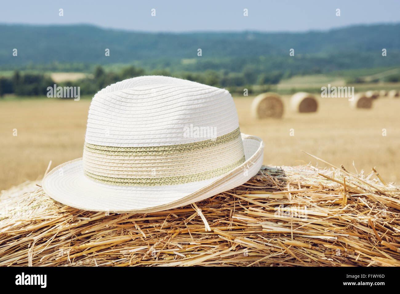 Woman's hat and yellow haystack. Rural seasonal scene Stock Photo - Alamy