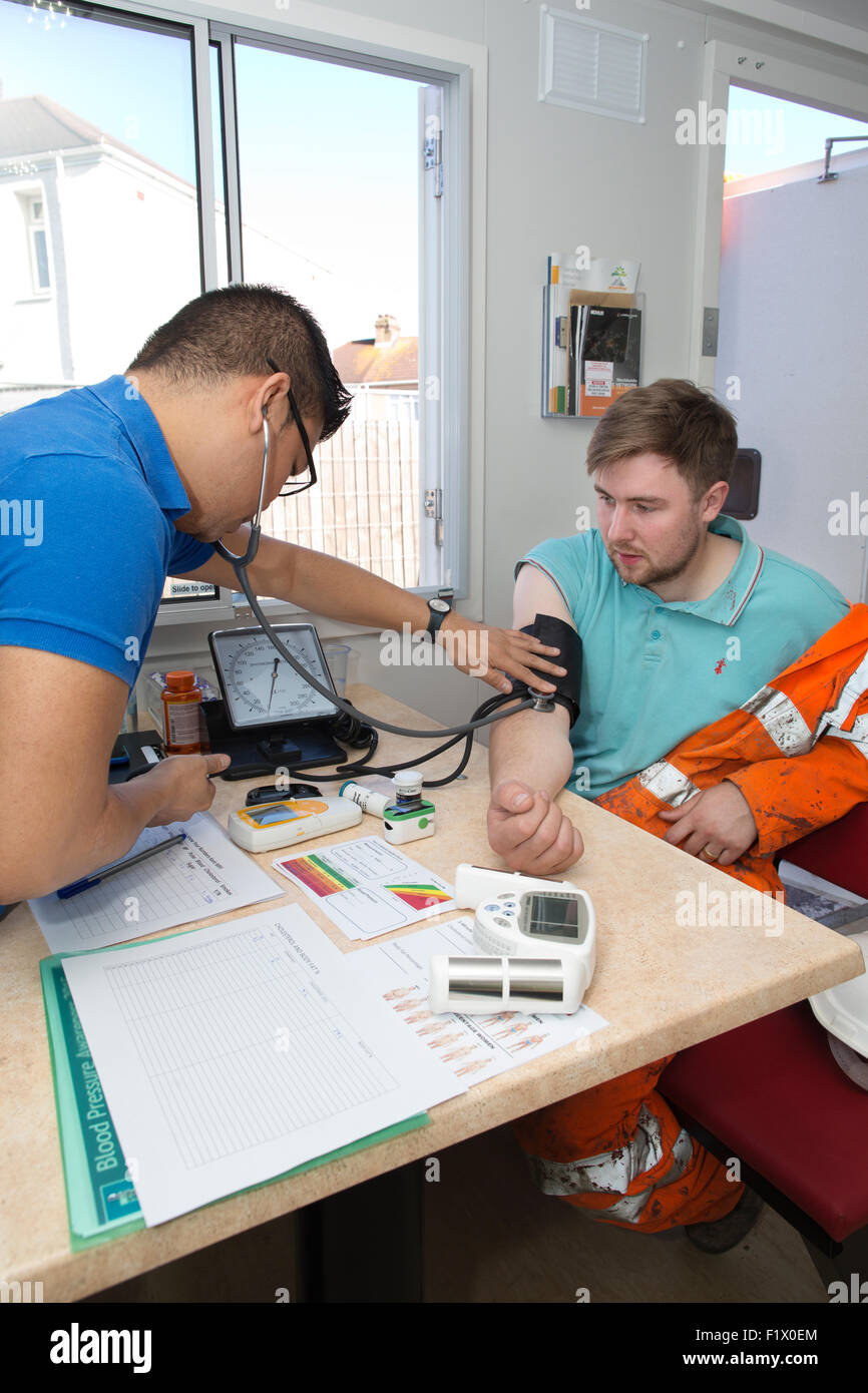Construction workers taking blood pressure test and general health ...