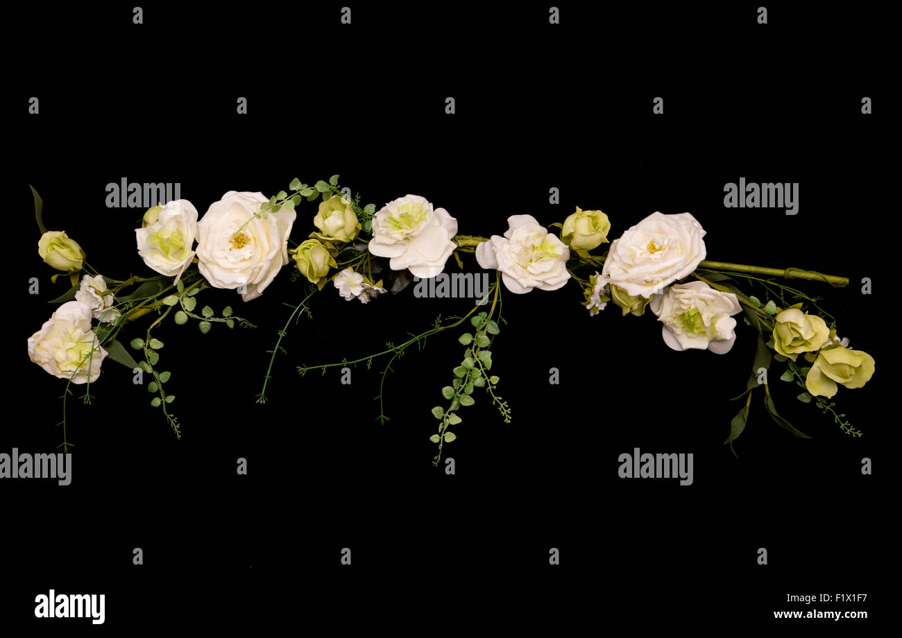 white rose artificial garland on black background Stock Photo - Alamy