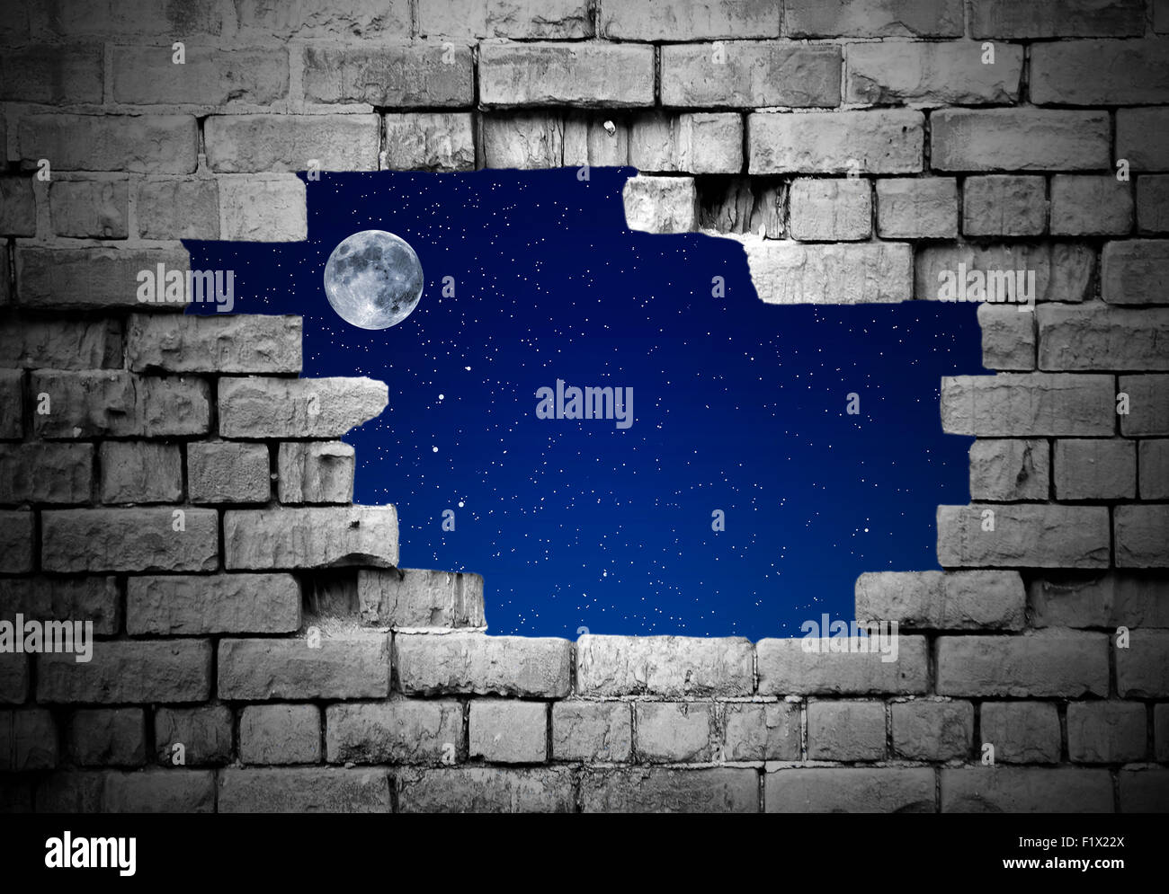 Section of a crumbling brick wall with hole revealing stars and moon ...