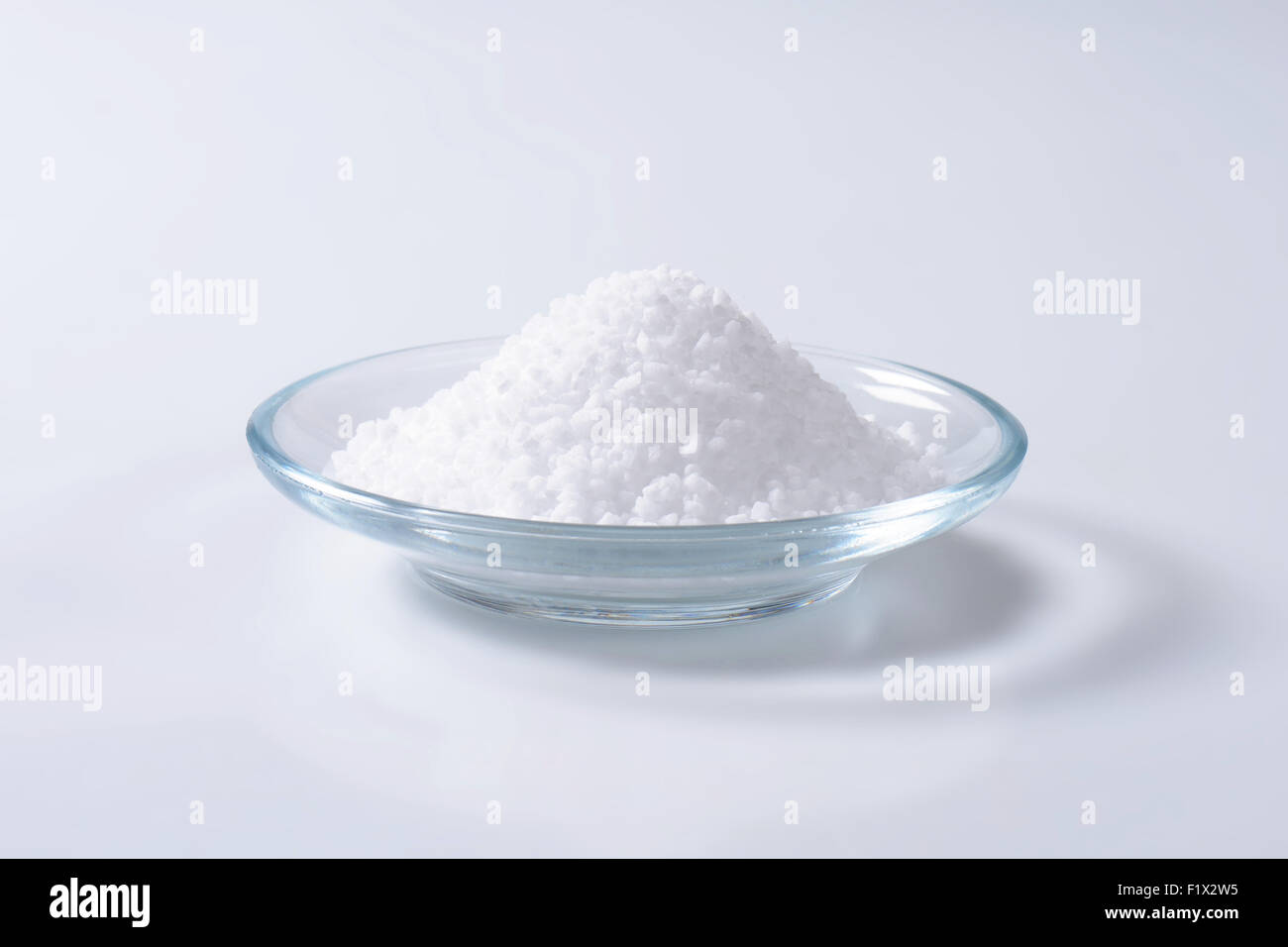 Heap of edible salt on small glass plate Stock Photo - Alamy