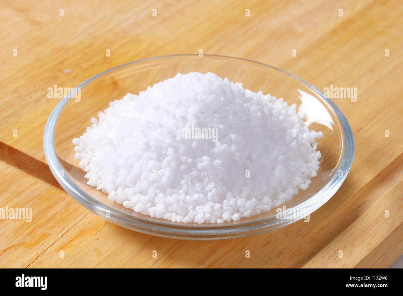 Heap of edible salt on small glass plate Stock Photo - Alamy