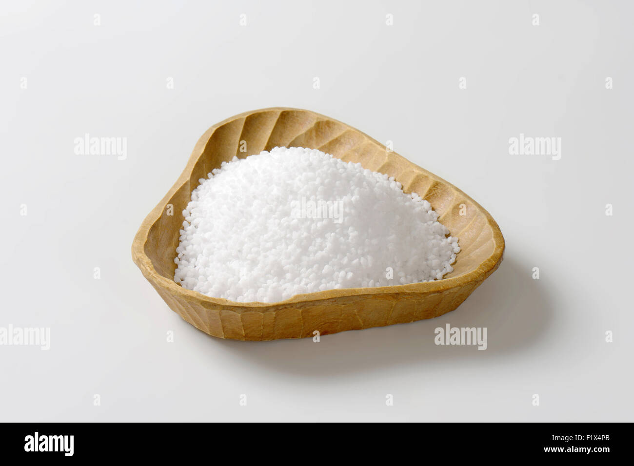 Coarse grained salt in triangle wooden bowl Stock Photo - Alamy