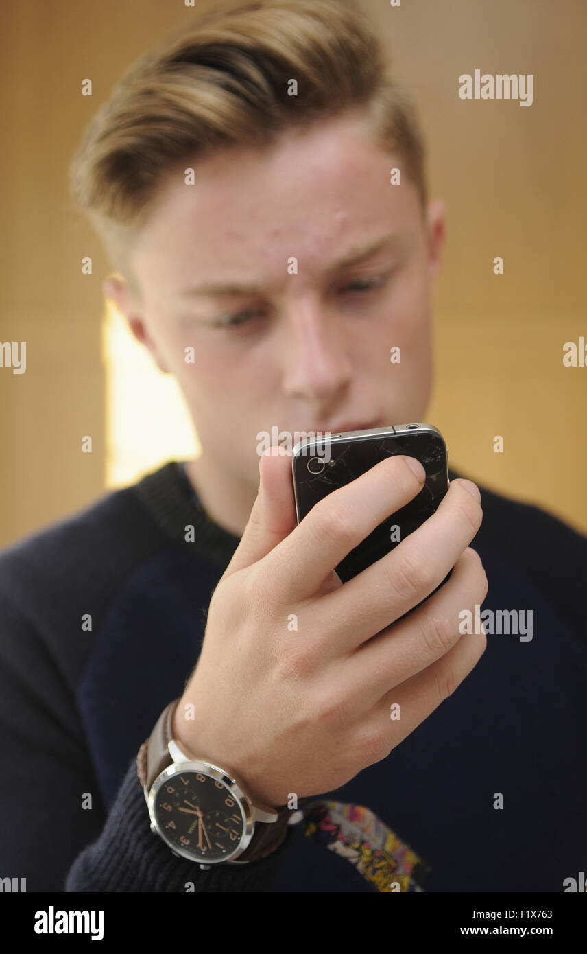 Teenage boy using an Apple iPhone 4 mobile phone Stock Photo - Alamy