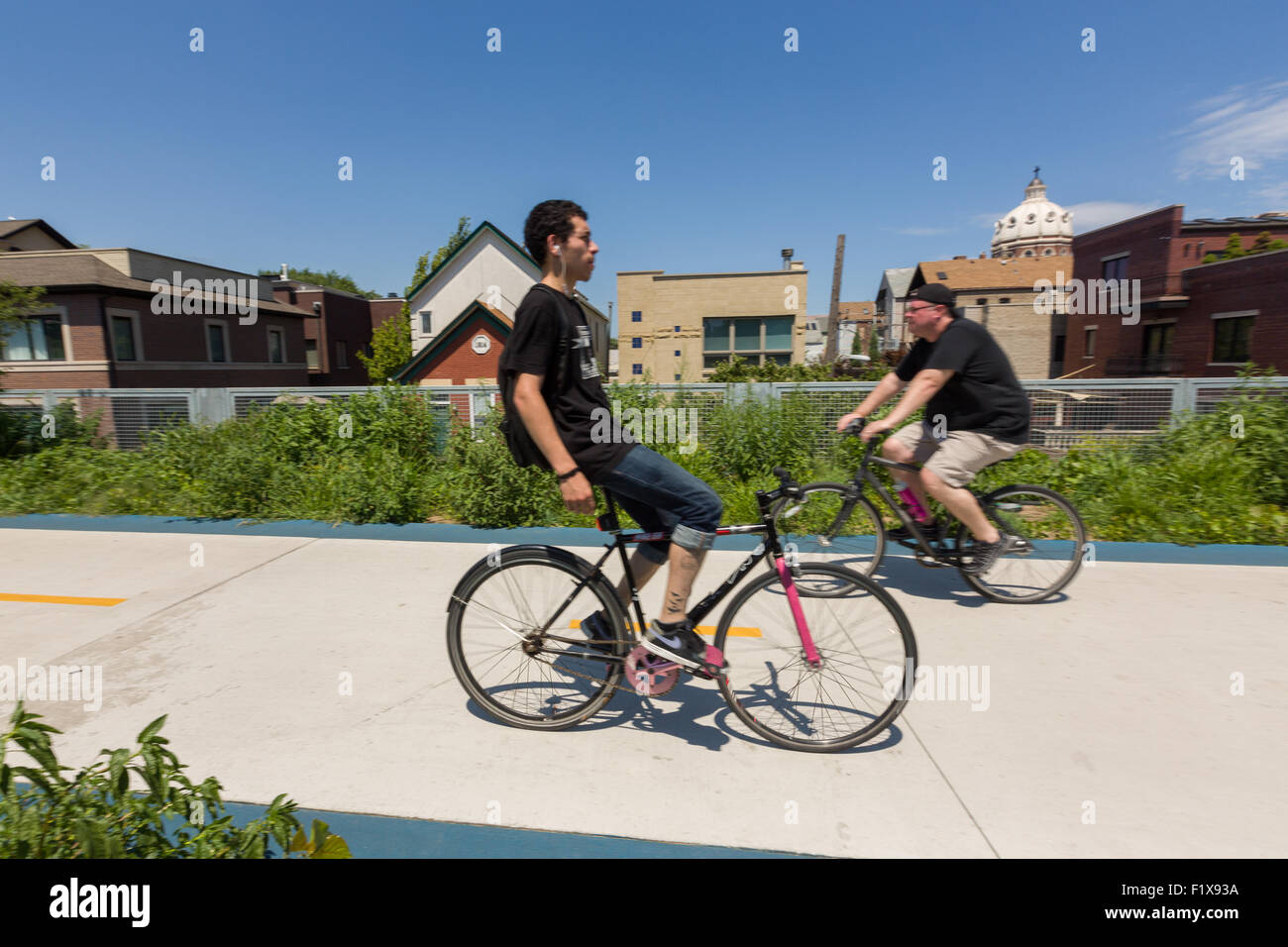 Bicyclists along the 606 elevated bike trail, green space and park ...