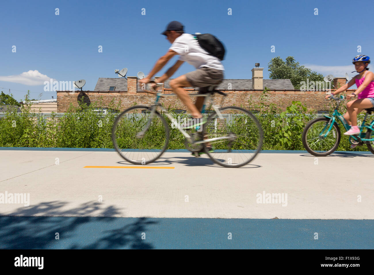Bicyclists along the 606 elevated bike trail, green space and park ...
