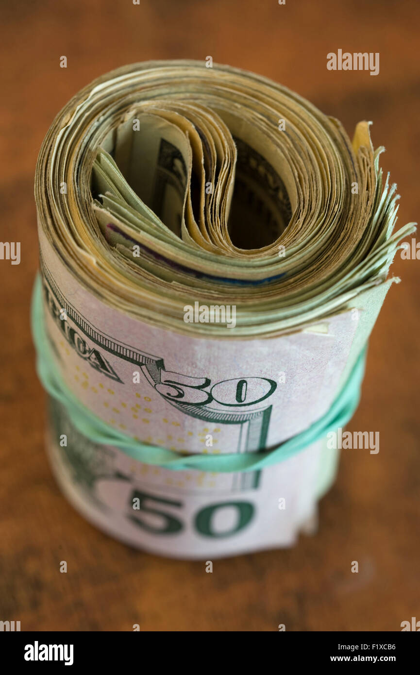 Money Roll of USA currency held with a rubber band Stock Photo - Alamy