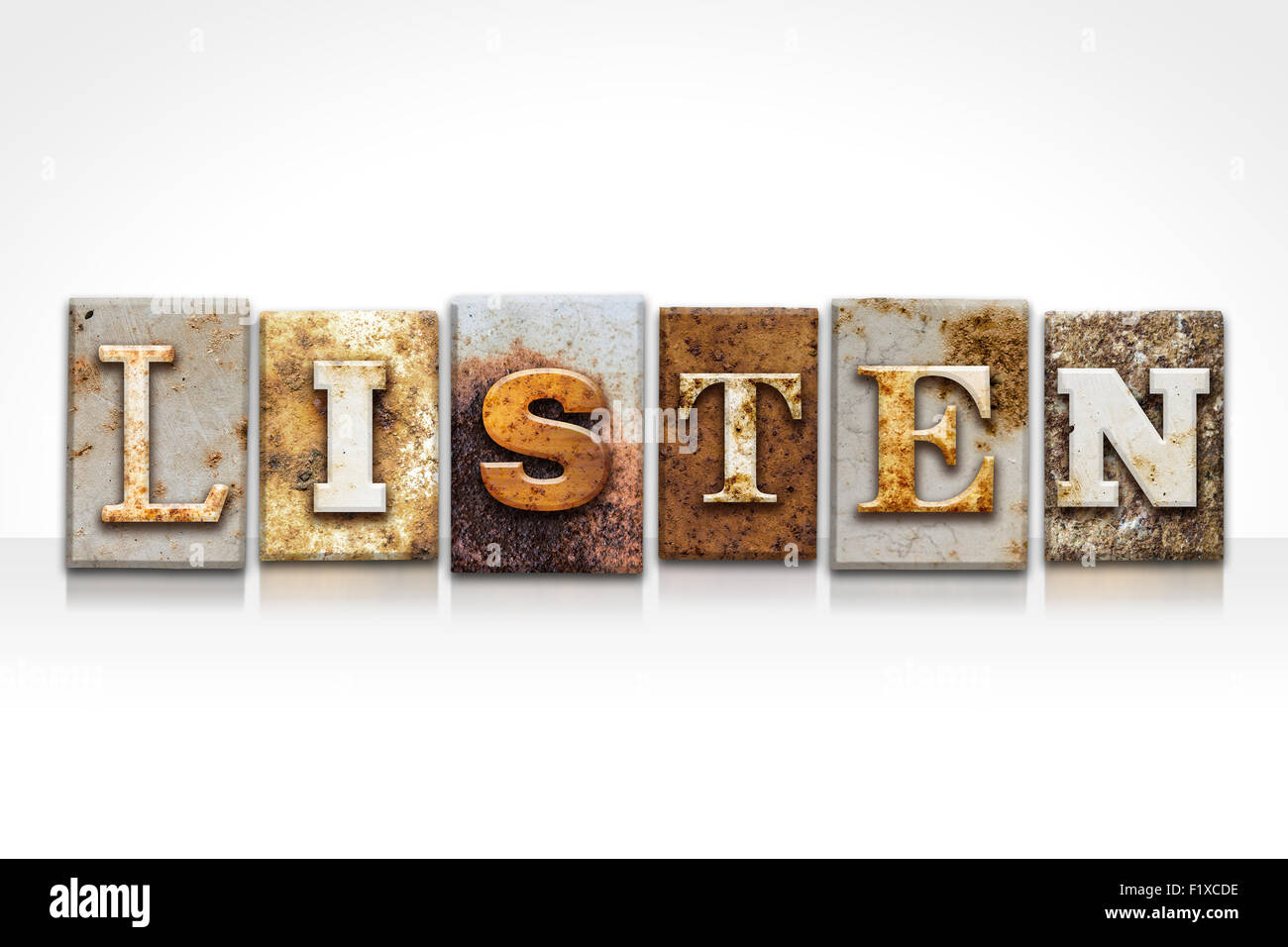 The word "LISTEN" written in rusty metal letterpress type isolated on a ...