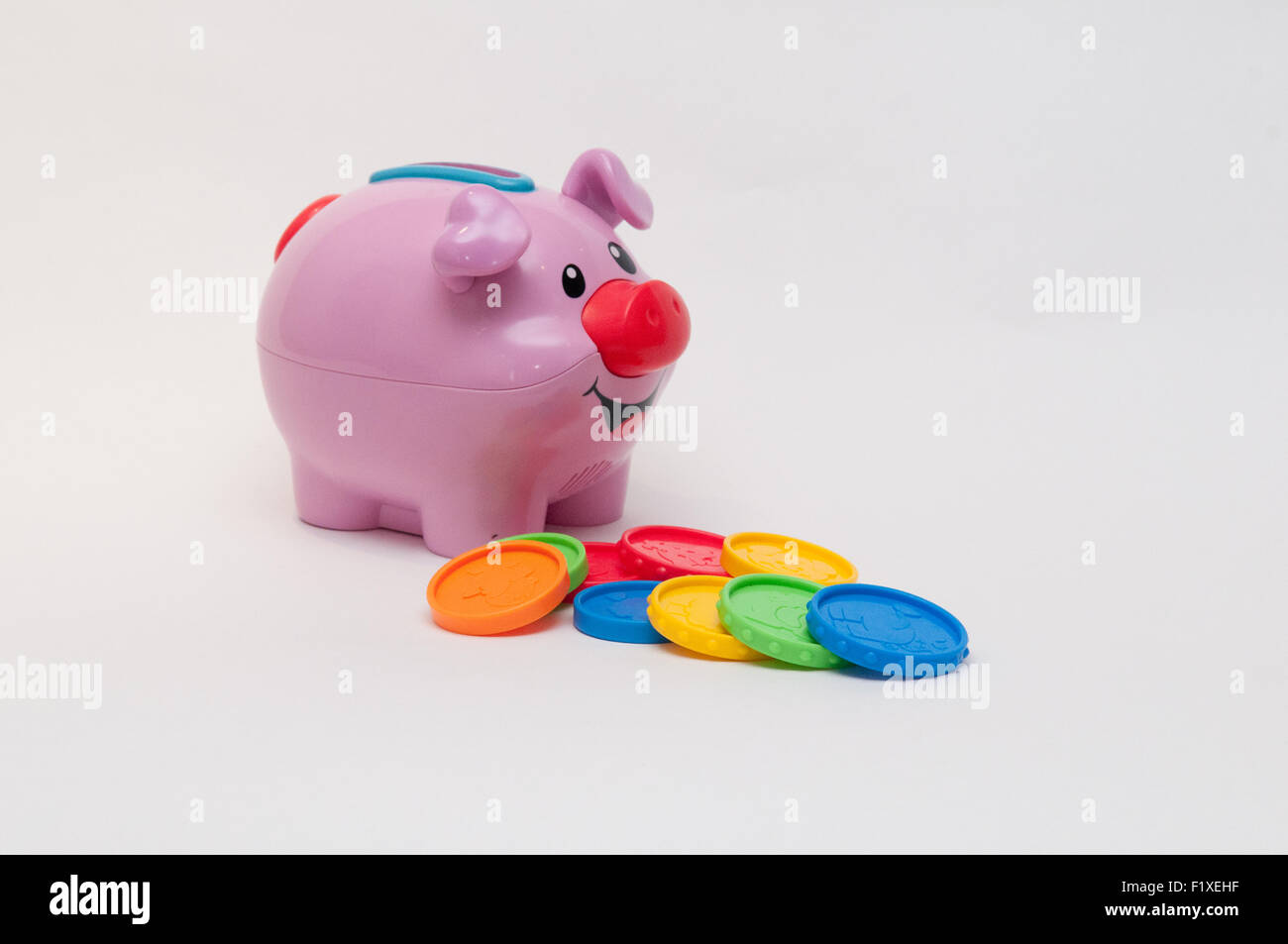 toy piggy bank with multicoloured coins Stock Photo - Alamy