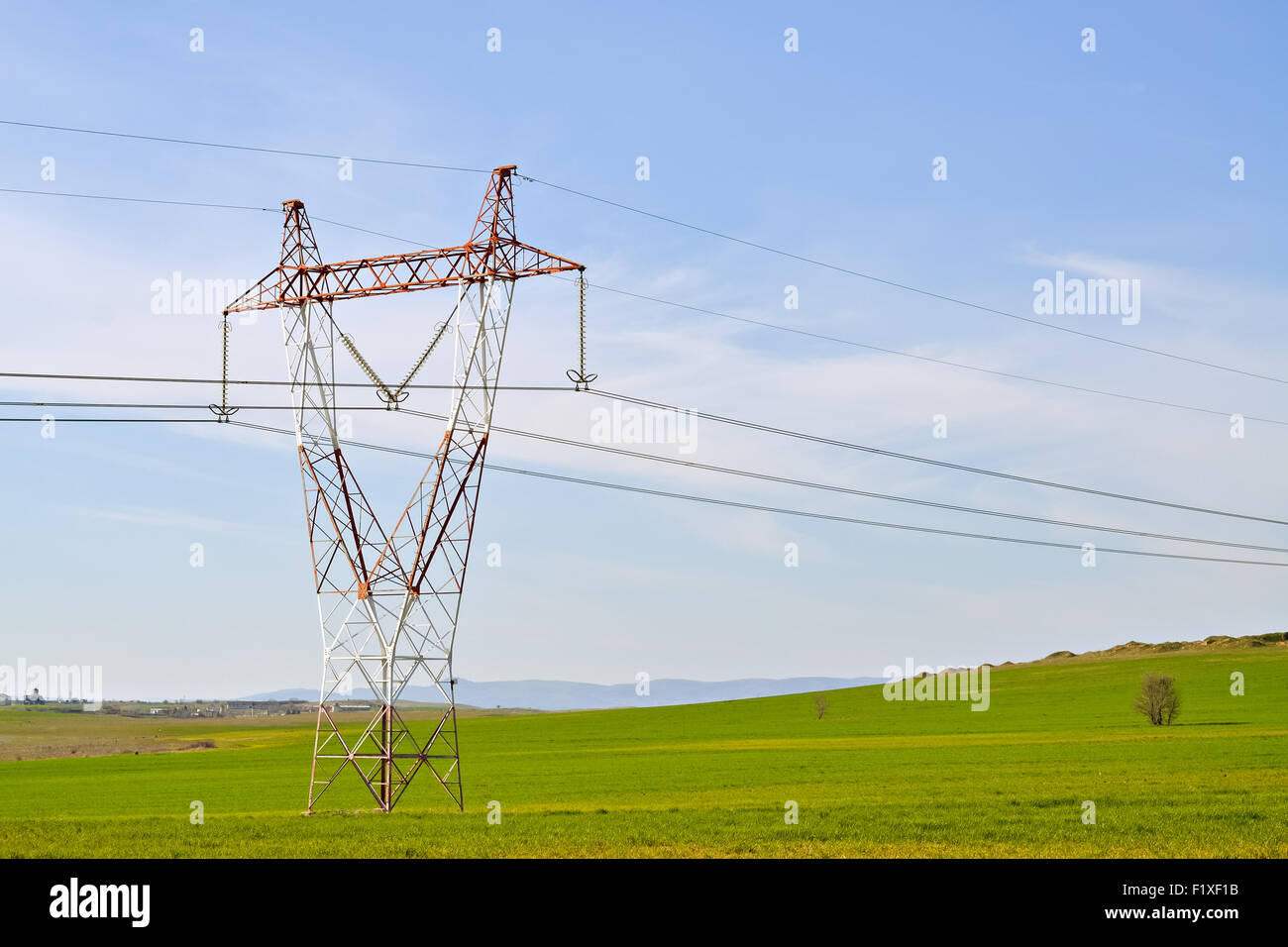 High-voltage transmission line in a meadow and clear blue sky Stock ...