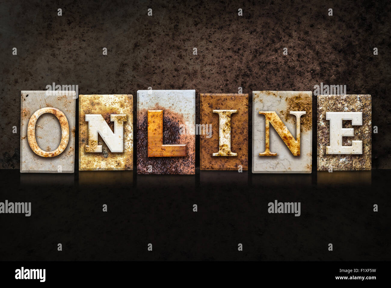 The word "ONLINE" written in rusty metal letterpress type on a dark ...