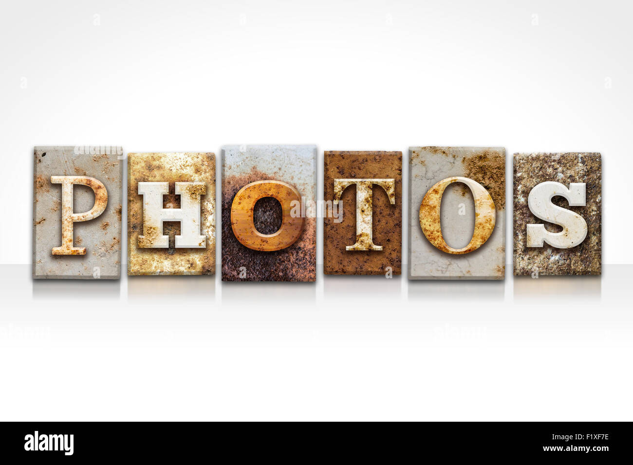 The word "PHOTOS" written in rusty metal letterpress type isolated on a ...