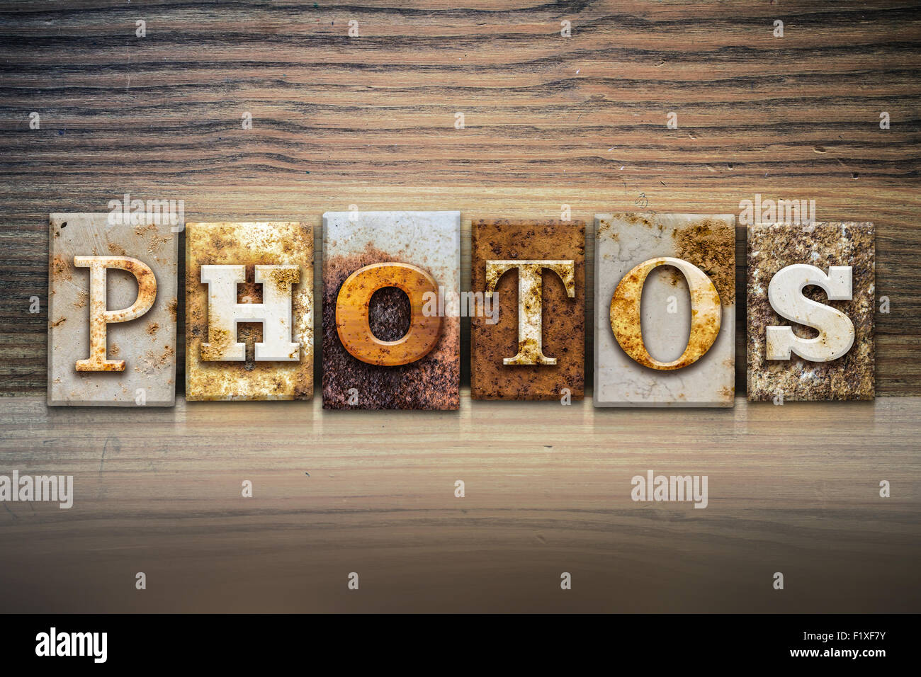 The word "PHOTOS" written in rusty metal letterpress type sitting on a ...