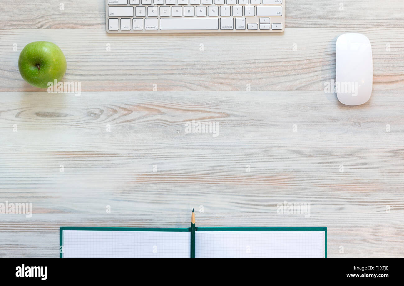 Working desk with green apple Stock Photo - Alamy