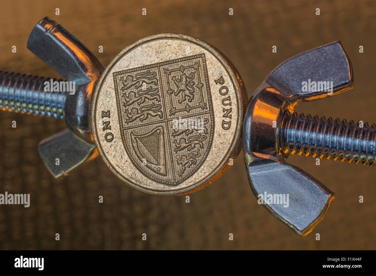 Turn the screw concept, pressurize. Macro of old style UK £1 coin ...