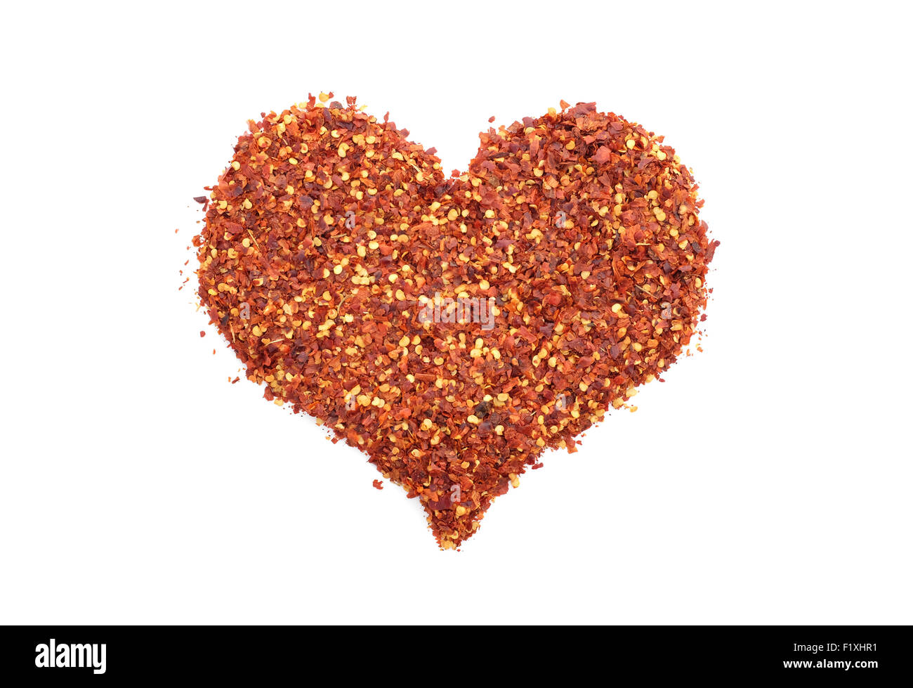 Hot and spicy crushed chilli flakes in a heart shape, isolated on a ...