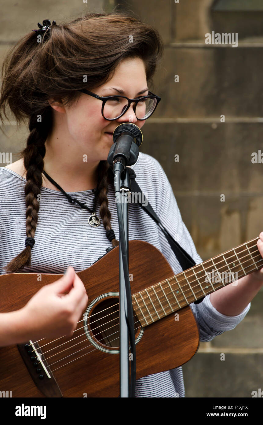 Young female singer/guitarist busking at the Edinburgh Festival Fringe ...
