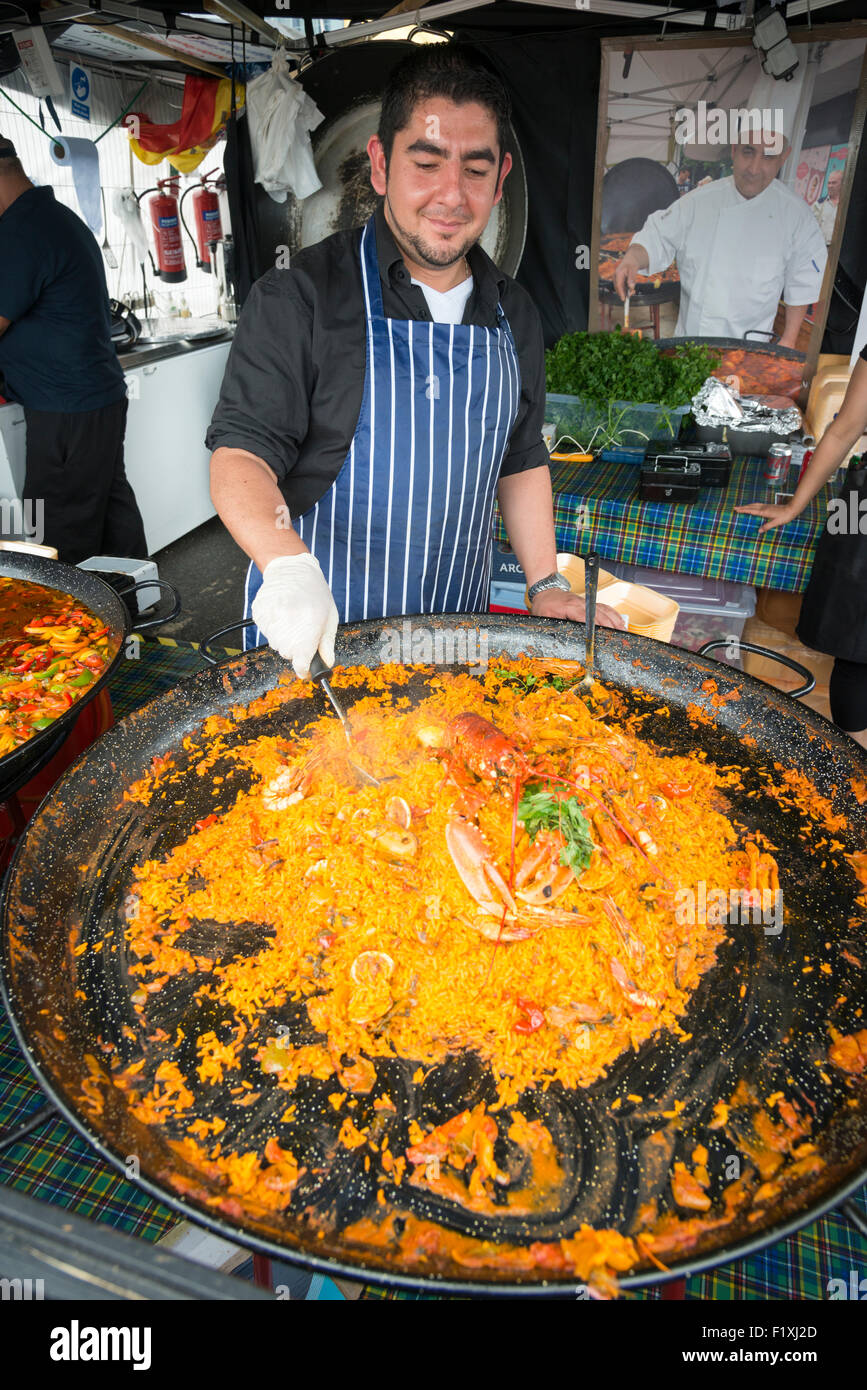 A chef cooks a large paella at a food stall at Cowes, Isle of Wight ...