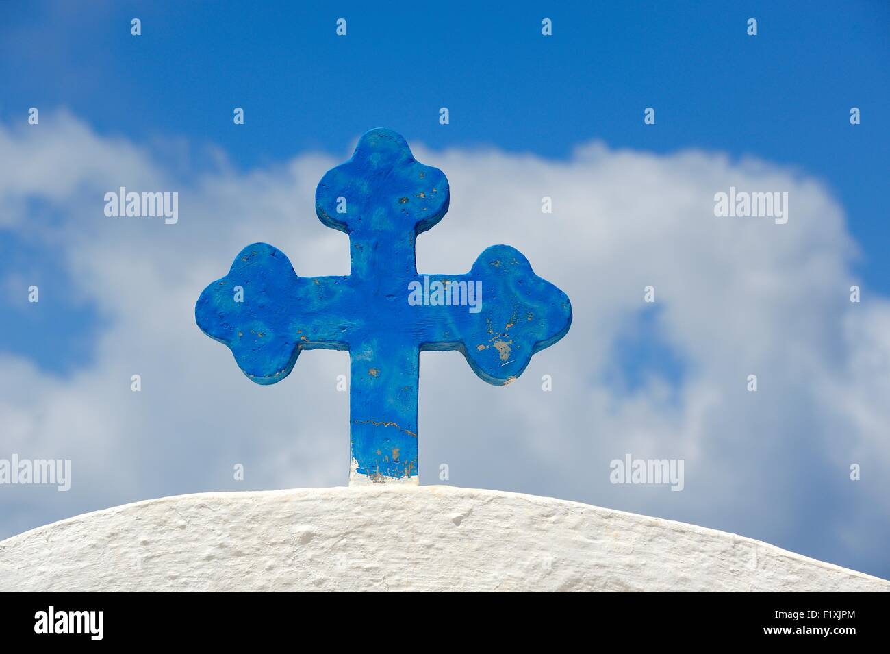A blue holy cross on top of a whitewashed church on the island of ...