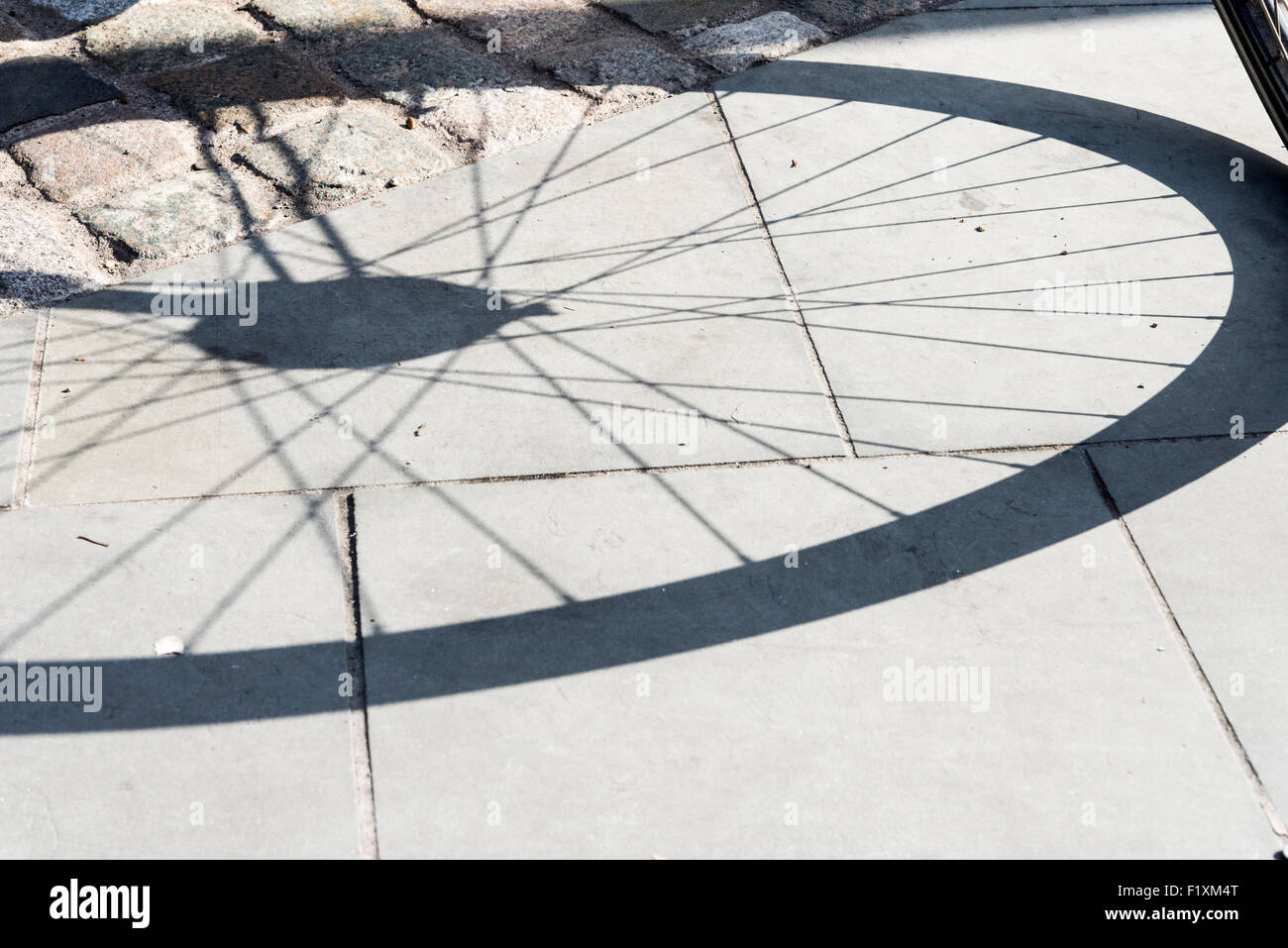 Shadow of a cycle tyre on the pavement at Kings Cross Station, London ...