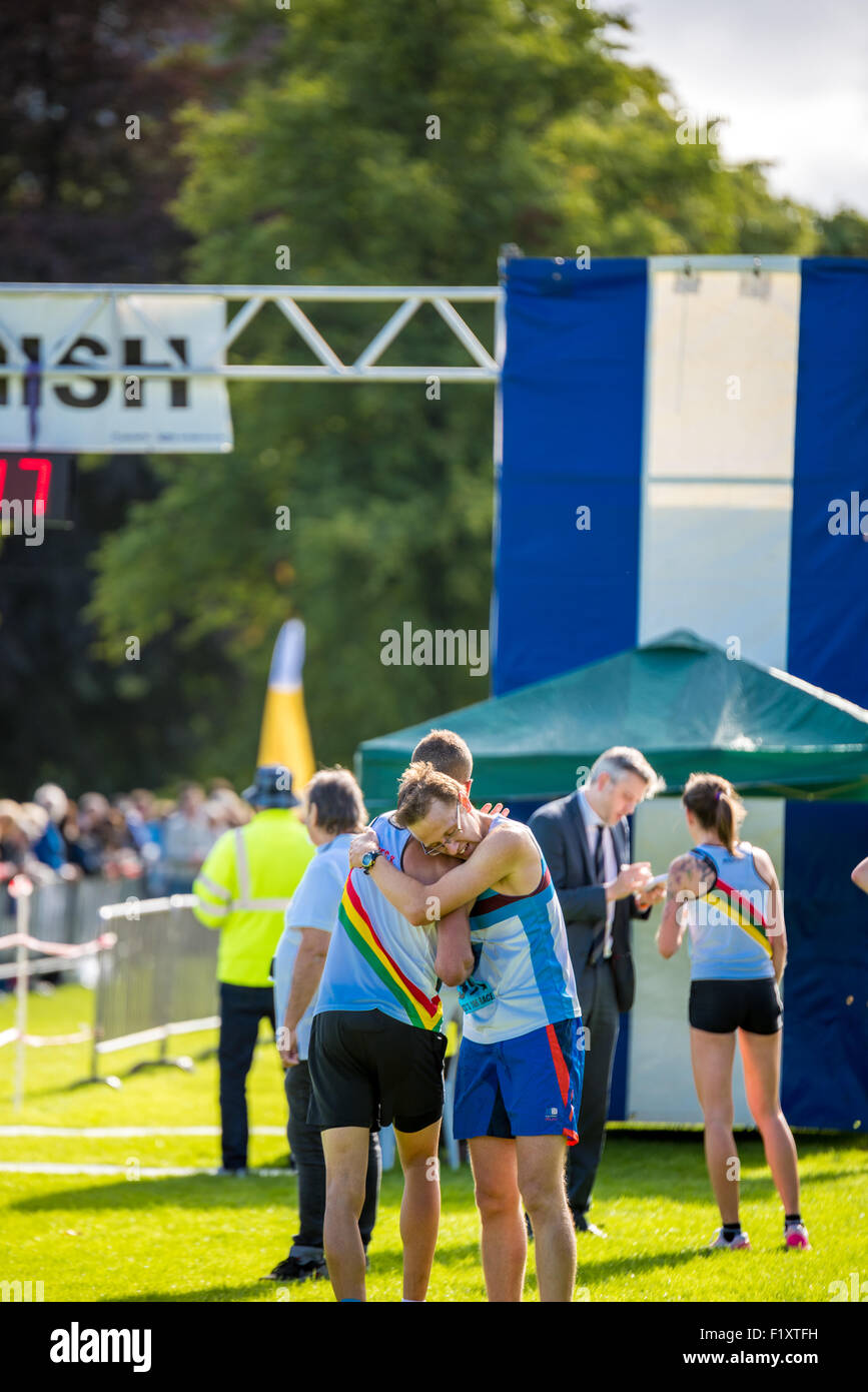 Two men hugging each other at the finish line of the 10k run at The ...