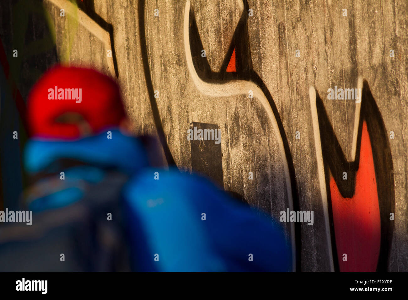 A man looking at a wall with graffiti Stock Photo - Alamy