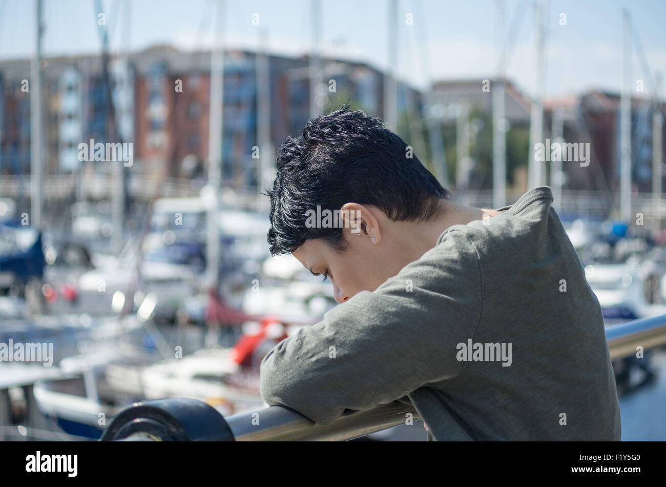 Pensive. Female adult looking pensively leaning on a railing ...