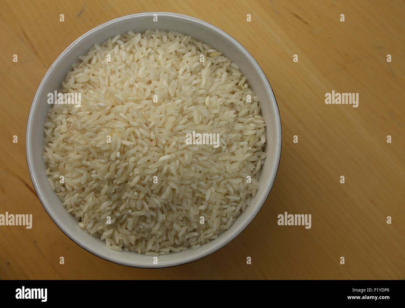bowl of white rice on wooden table Stock Photo - Alamy