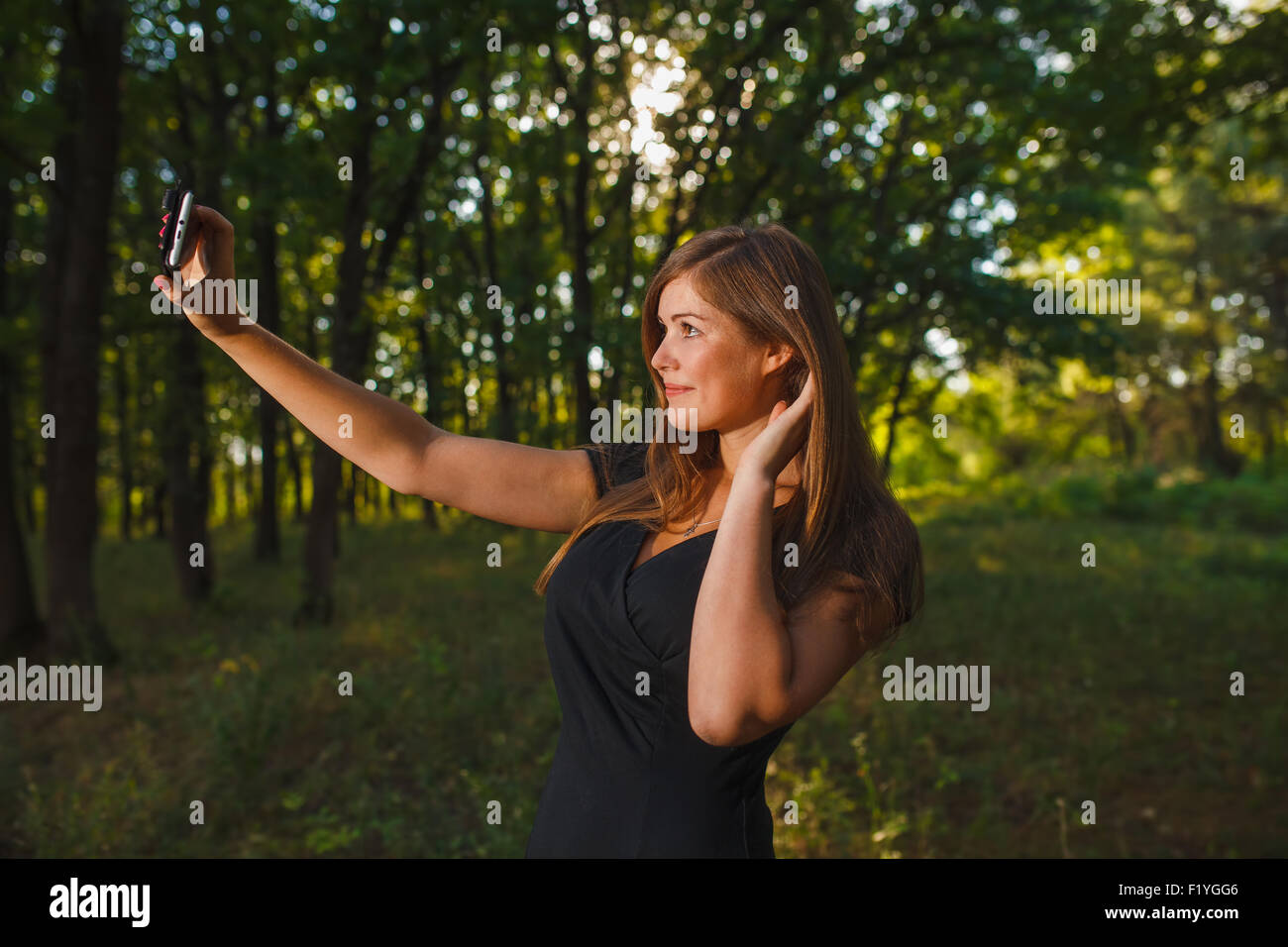 girl woman sELF making self photo on the phone on nature green b Stock ...