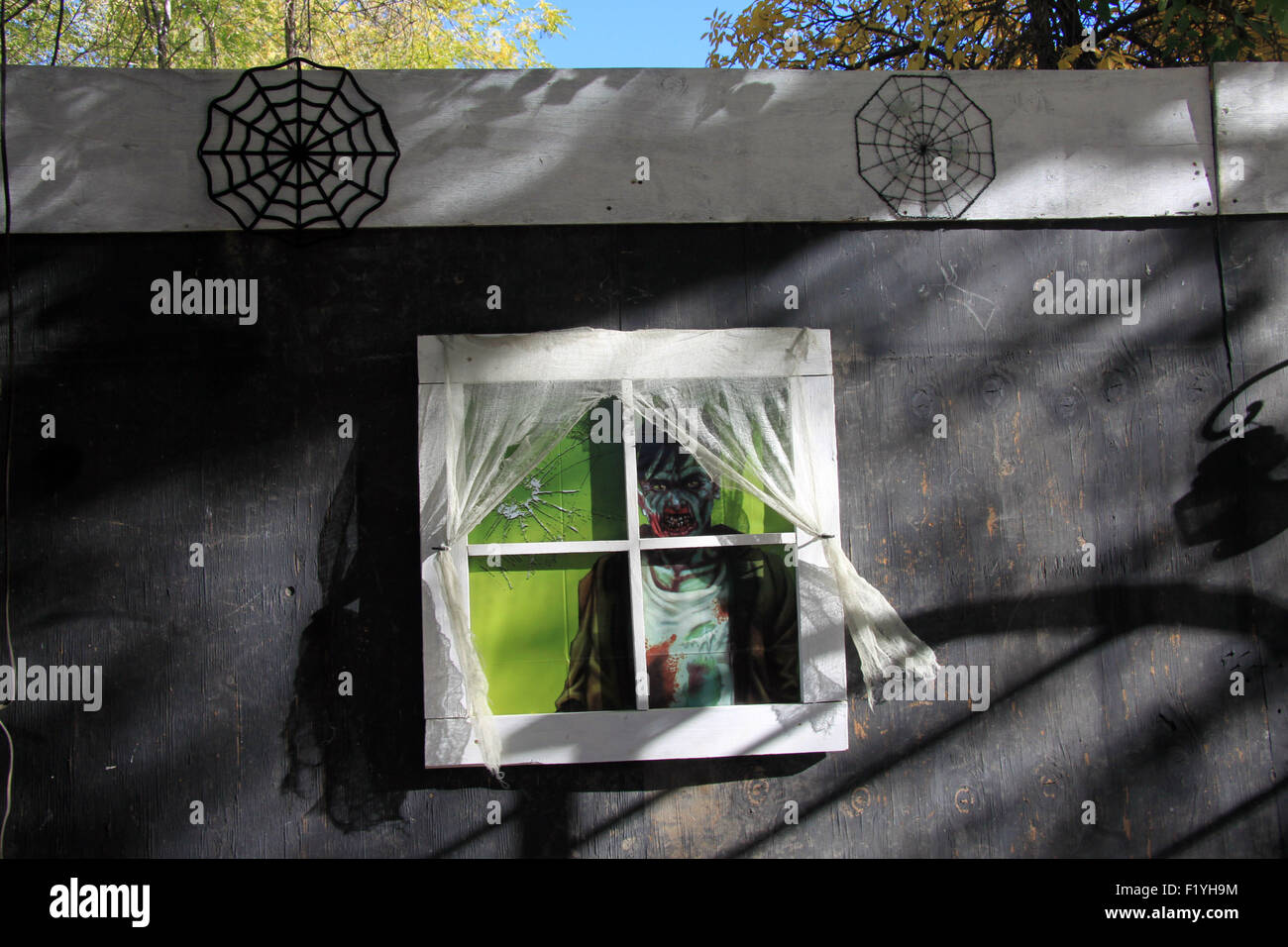Halloween creature peering out window of haunted house Stock Photo - Alamy