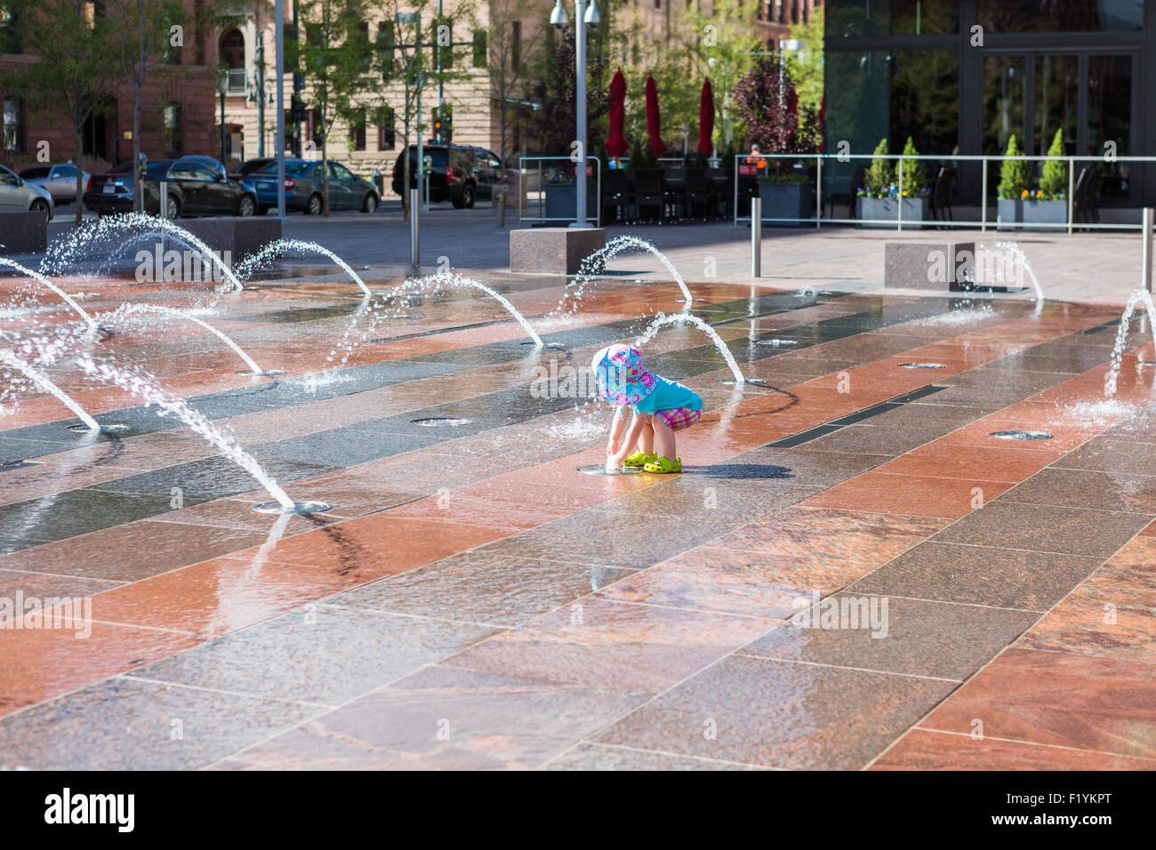 Cute toddler girl playing with small fountains in splash park Stock ...