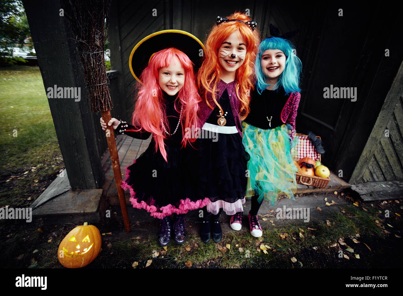 Halloween witches looking at camera by haunted house Stock Photo - Alamy
