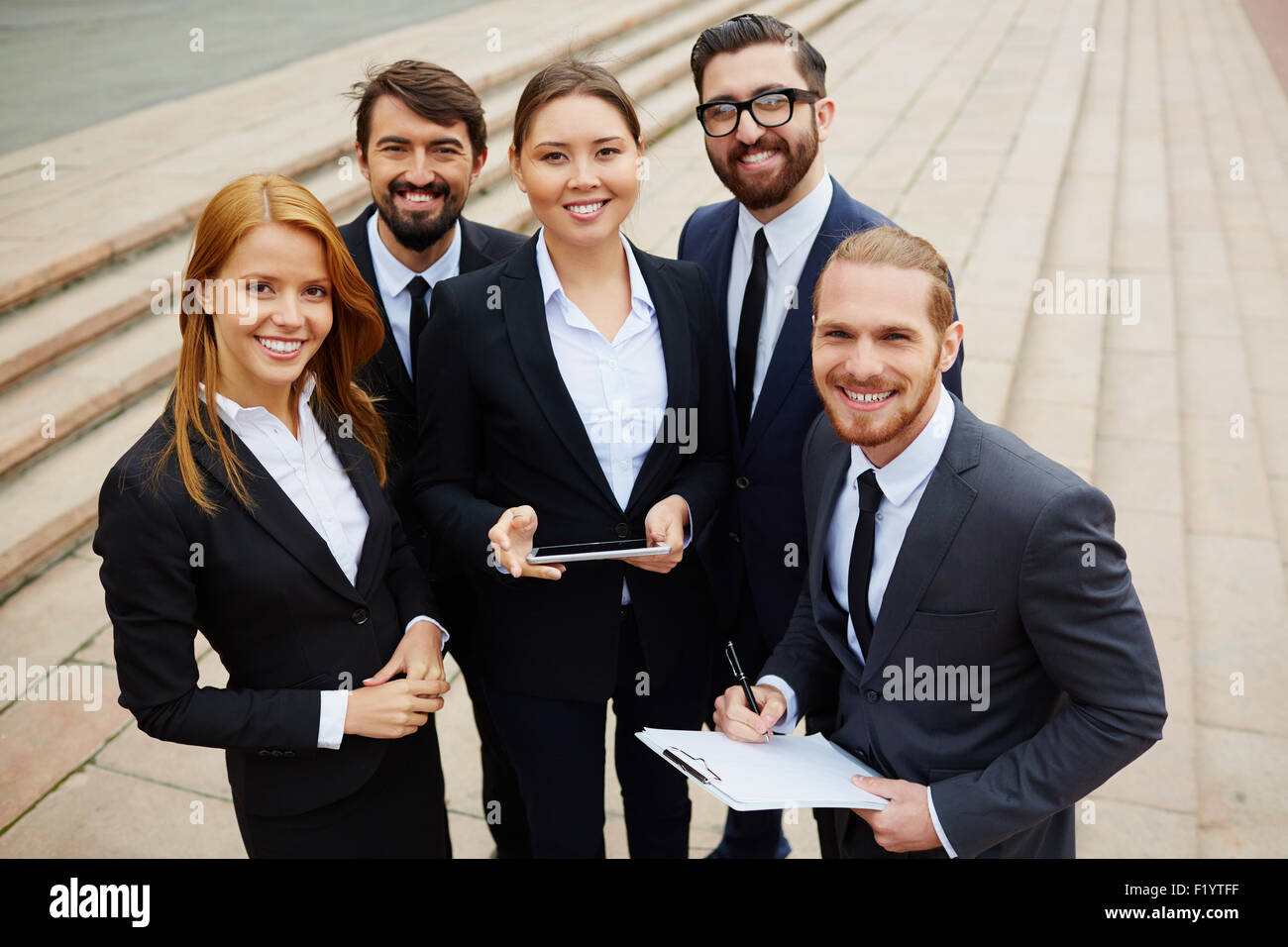 Group of young managers in formalwear looking at camera outdoors Stock ...