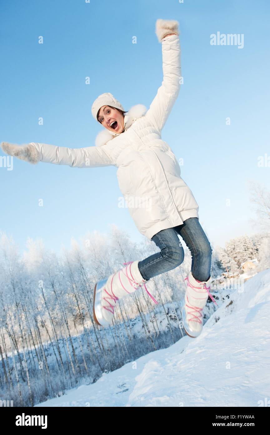 Happy girl jumping in the snow Stock Photo - Alamy