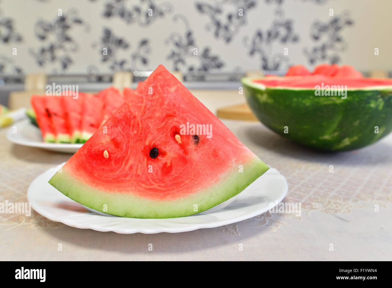 slices of watermelon on a plate at the table Stock Photo - Alamy