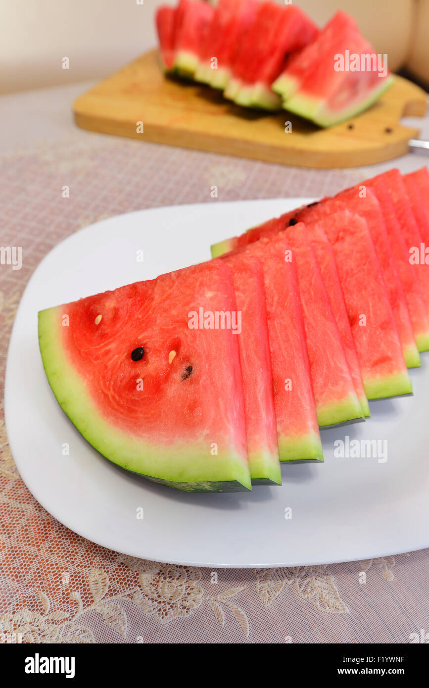 slices of watermelon on a plate at the table Stock Photo - Alamy